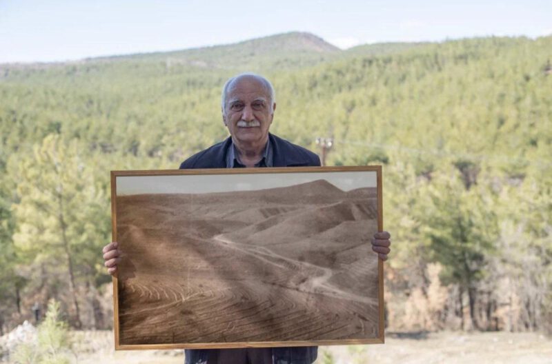 Man poses with photo of forest he helped restore - Green Prophet